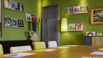 Uma sala de conferências com uma mesa comprida, cadeiras e diversos objetos emoldurados nas paredes.