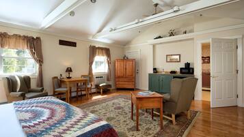 Um quarto aconchegante com cama, área de jantar, cozinha e sala de estar.