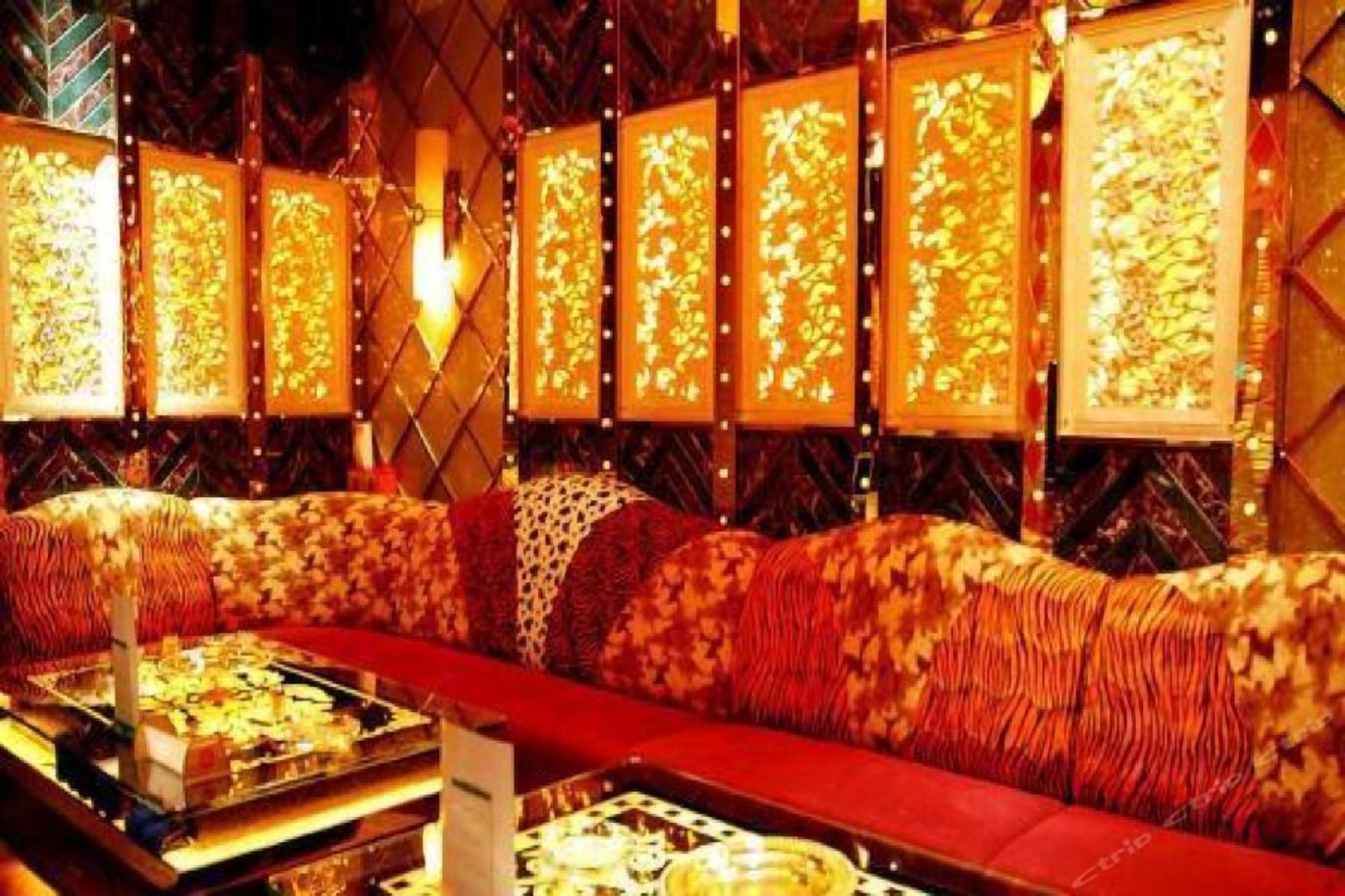 Restaurante com um sofá vermelho comprido e uma mesa com pratos.