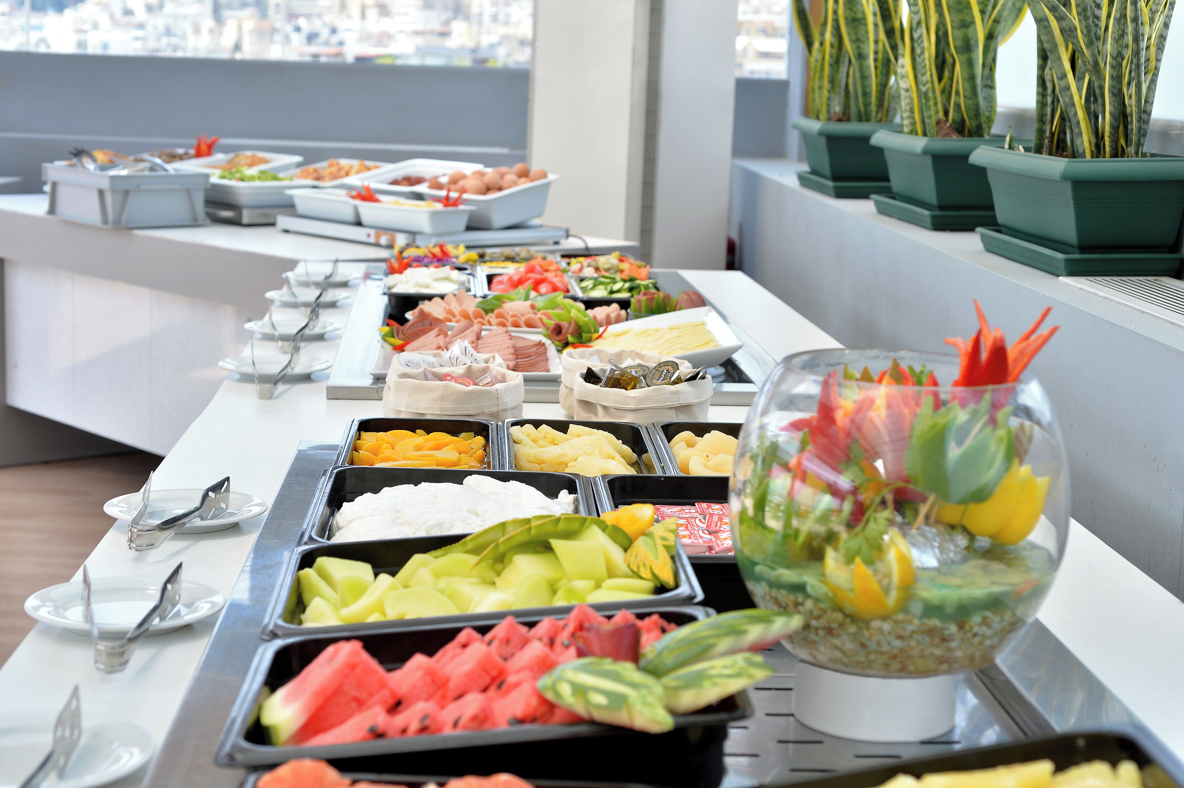 Um buffet com diversas opções de comida e um arranjo decorativo.