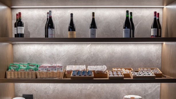 Exposição de garrafas de vinho, cereais e doces nas prateleiras.