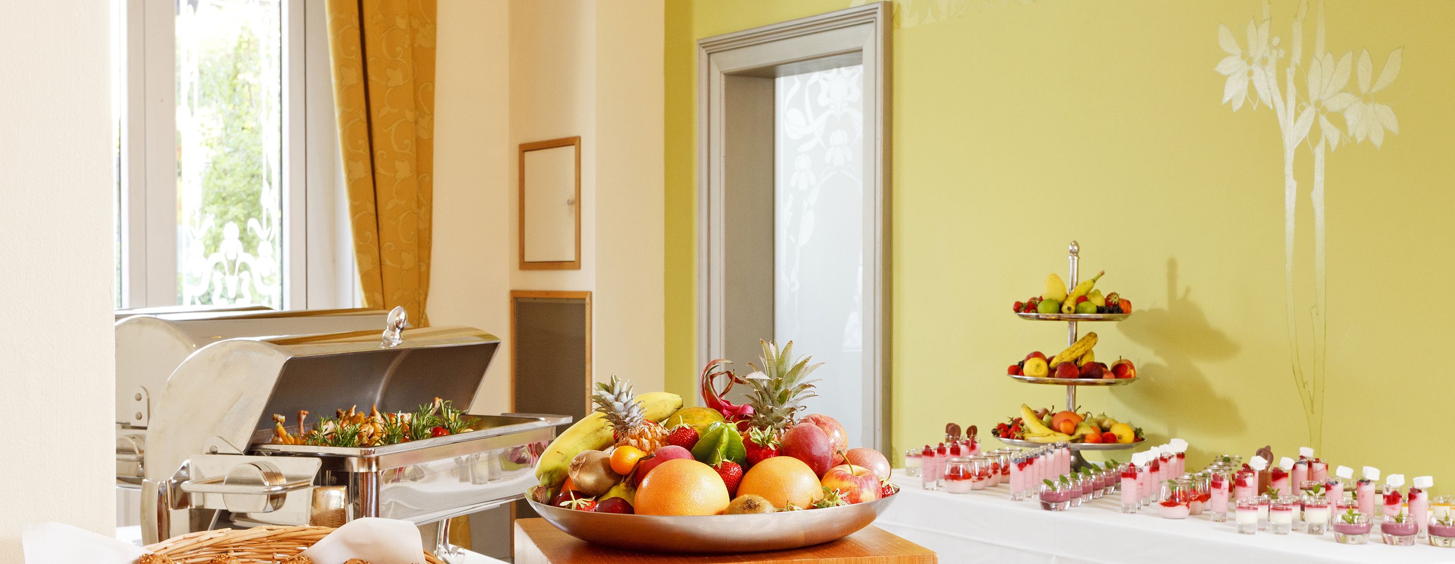 Um buffet de café da manhã com uma variedade de frutas e uma apresentação em três níveis.