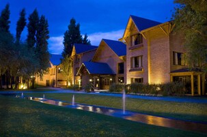 Hotel de vários andares com fachada de tijolos e telhados inclinados.
