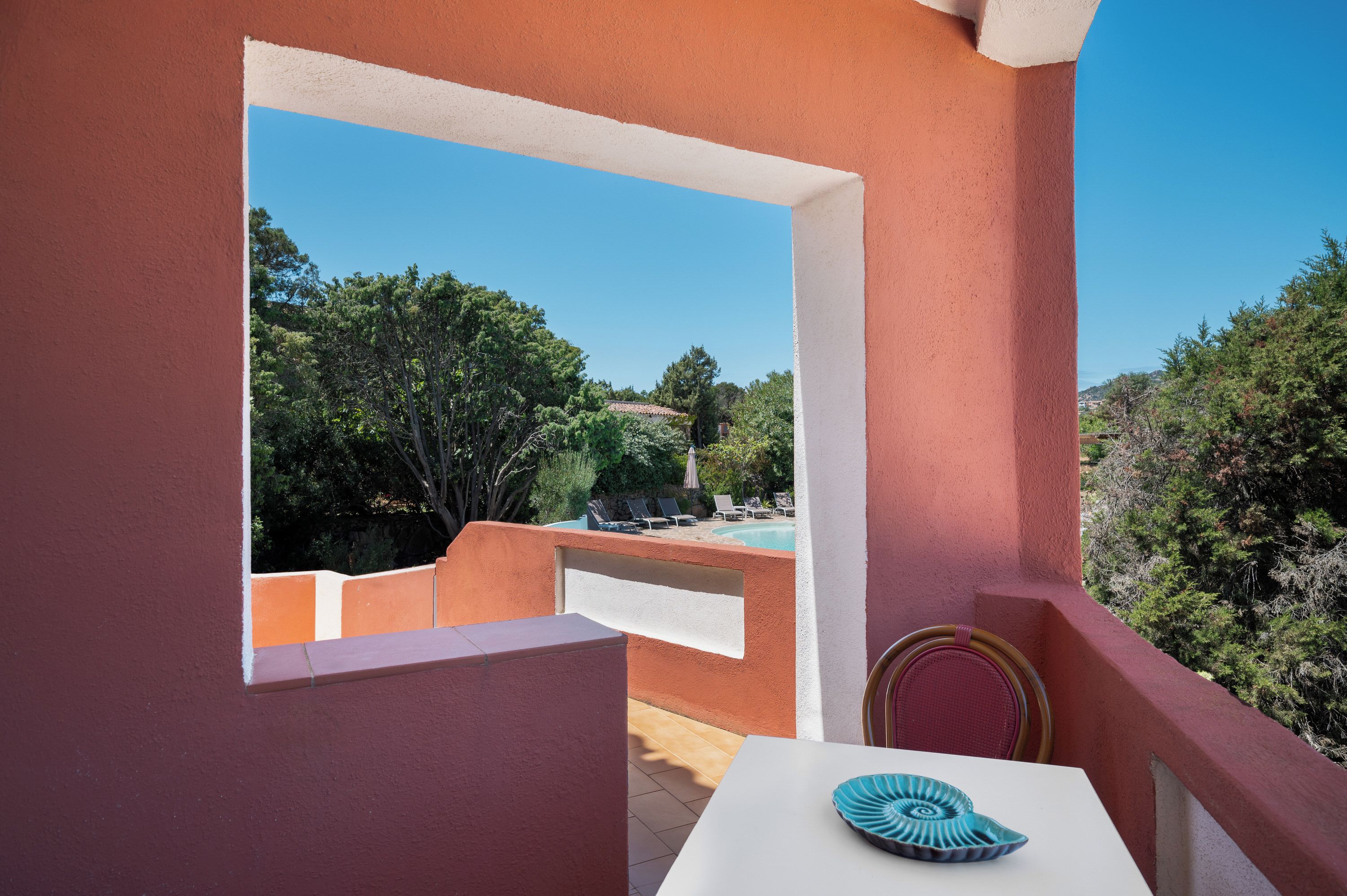 Varanda com vista clara para uma piscina e árvores ao redor.