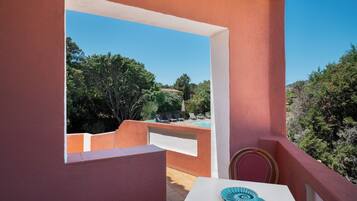 Varanda com vista clara para uma piscina e árvores ao redor.
