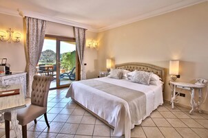 Um quarto espaçoso com uma cama grande, um espaço de refeições e vista para o exterior.