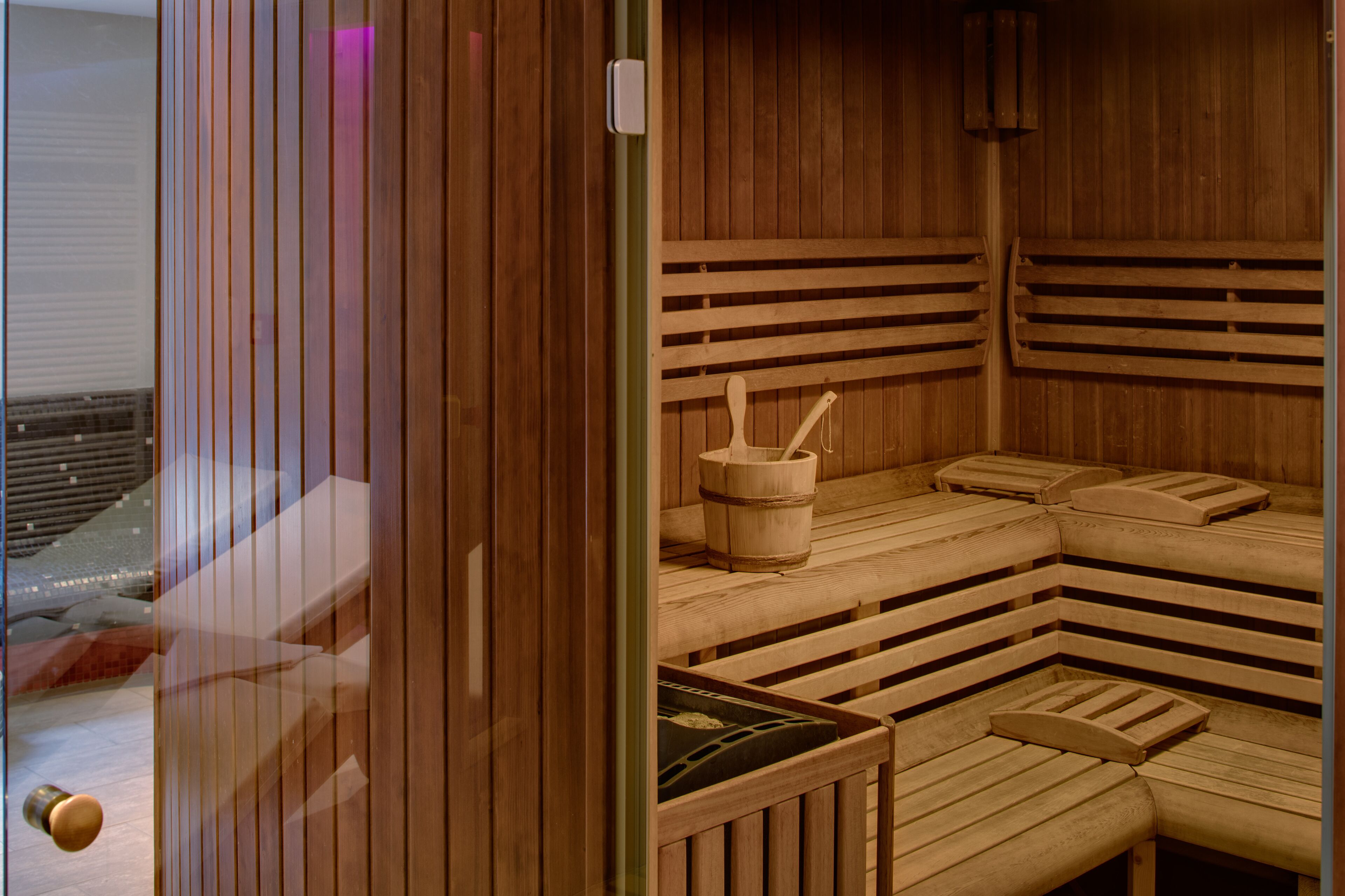 Uma sauna com bancos de madeira e um balde de madeira.