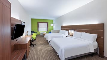 Quarto de hotel com duas camas, uma mesa de trabalho com televisão de tela plana, uma cadeira e uma parede verde decorativa.