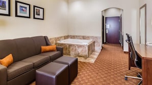 Um hall de hotel moderno com um sofá, um banquinho e uma banheira.