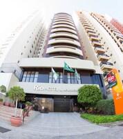Fachada do Hotel Rio by Bourbon, com design moderno, várias varandas e uma entrada imponente.
