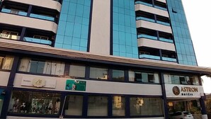 Um hotel alto com design moderno, com várias varandas e janelas amplas.