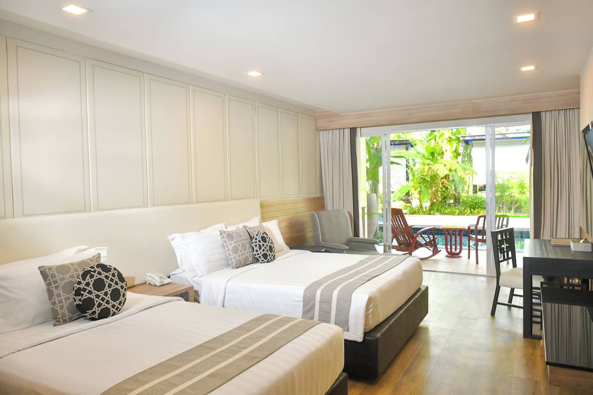 Quarto de hotel com duas camas, uma escrivaninha e vista para o exterior.