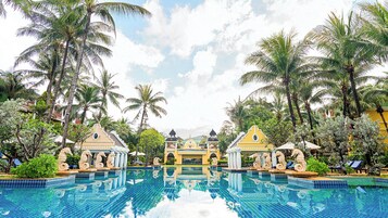 Uma grande piscina com vista clara para o céu e palmeiras.