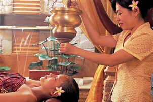 Uma pessoa recebendo uma massagem tradicional com uma grande tigela de latão.