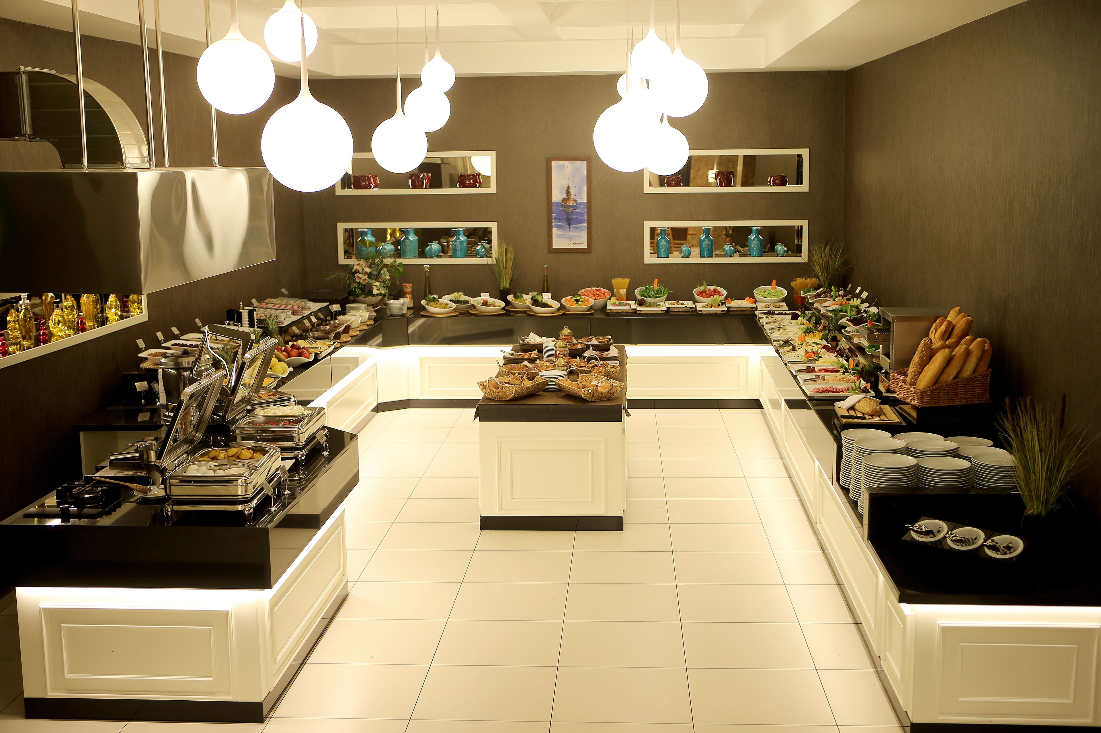 Disposição de buffet com diversos alimentos e um ponto central de serviço.
