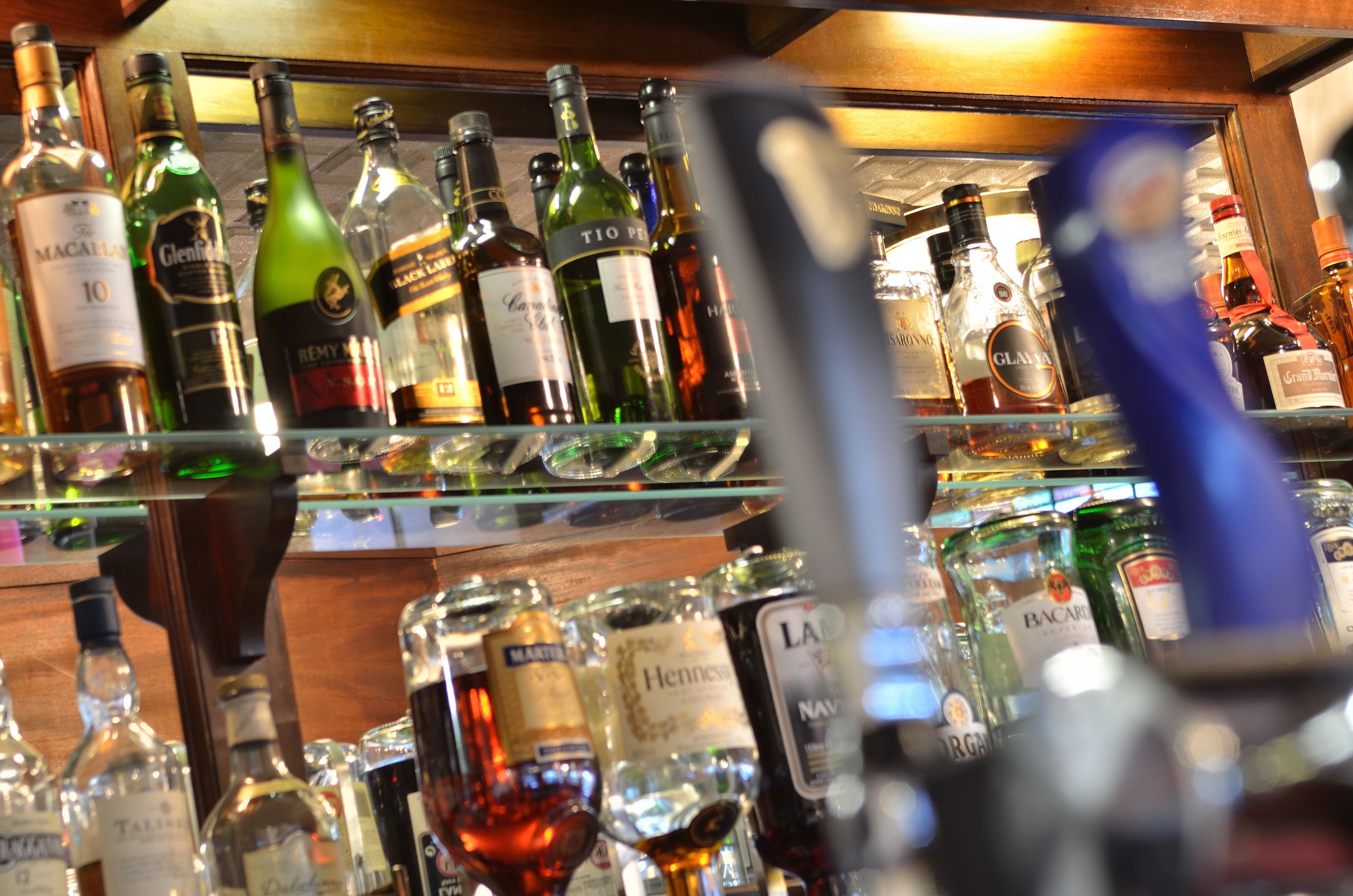 Um bar com diversas garrafas de bebidas alcoólicas nas prateleiras.