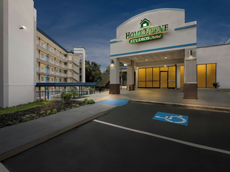 Entrada de hotel com placa indicando 'Home Towne Studios by Red Reef'.