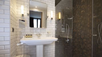 Casa de banho com lavatório pedestal branco, espelho e cabine de duche.