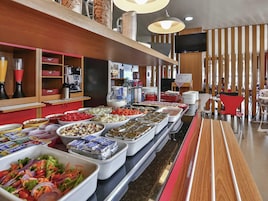 Buffet com diversas opções de comida e um espaço para café.
