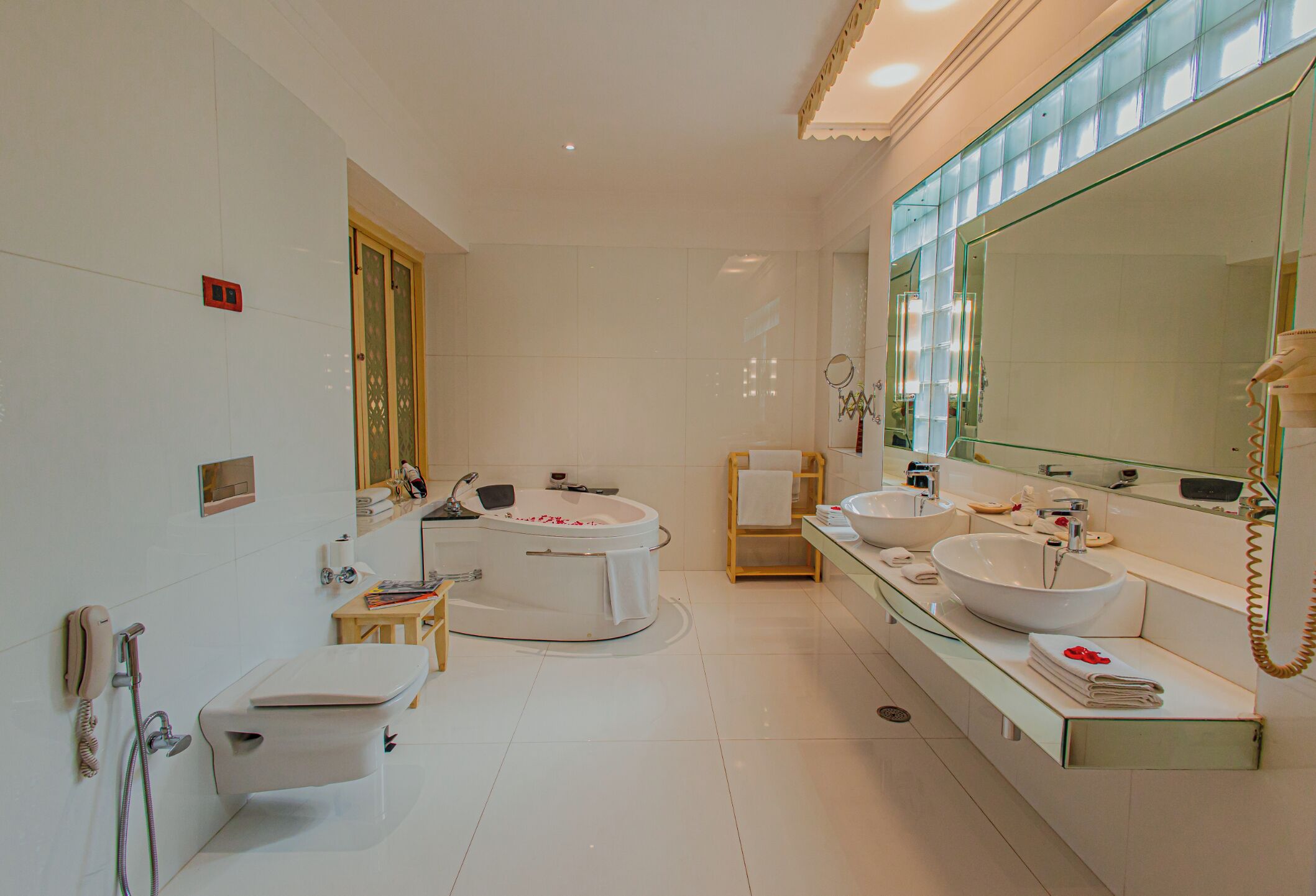 Uma casa de banho moderna com uma banheira grande, duas pias e um espelho amplo.