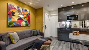 Suíte, 1 quarto | Sala de estar | TV de tela plana 32 polegadas com canais a cabo, TV