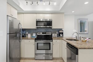 Uma cozinha moderna com eletrodomésticos de aço inoxidável, painel de azulejos e forno embutido.
