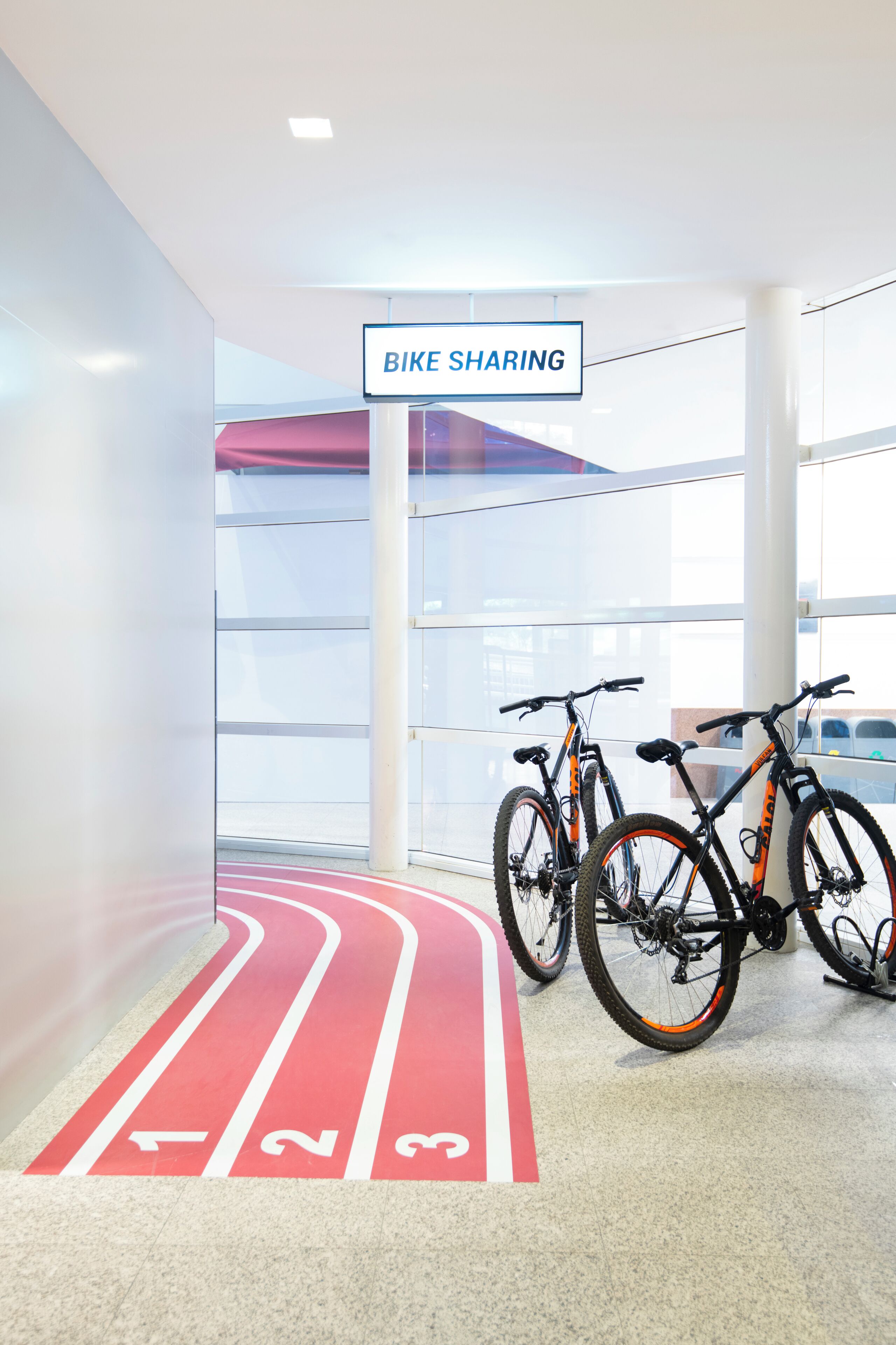 Uma estação de compartilhamento de bicicletas com duas bicicletas e uma placa indicando 'BIKE SHARING'.