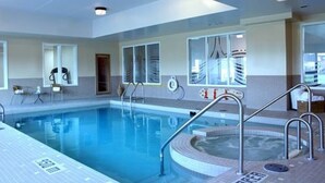 Piscina com hidromassagem, água cristalina e grades de metal.