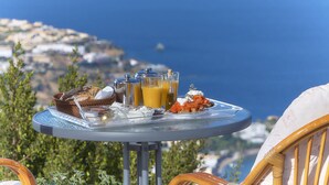Mesa de café da manhã com comida e bebidas, com vista para a costa.