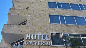 Um edifício de vários andares com uma placa que diz 'HOTEL UNIVERSO'.