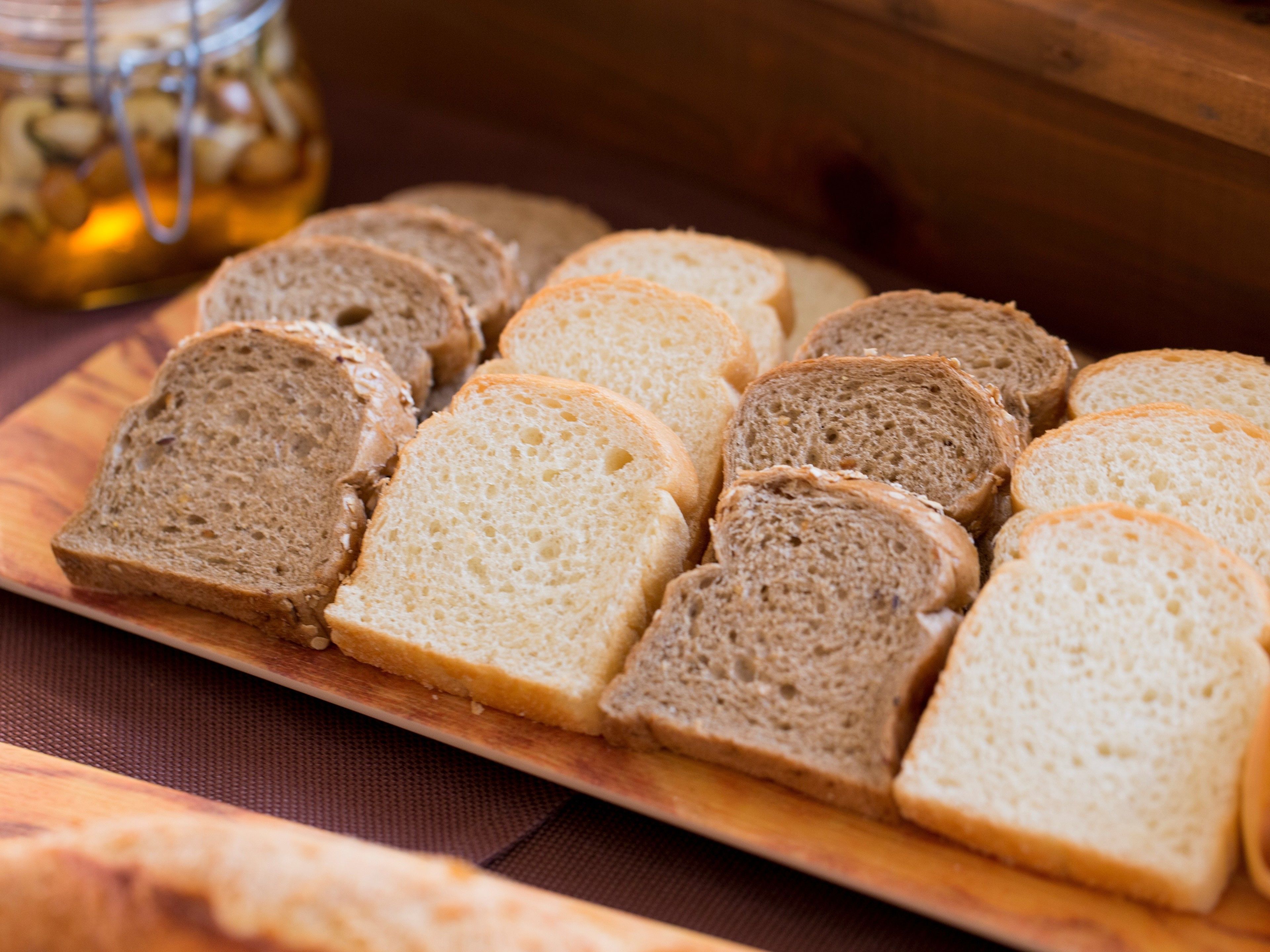 Fatias de pão sobre uma tábua de madeira.