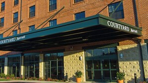 Um edifício de tijolos com marquise verde identificada como "Courtyard Marriott".