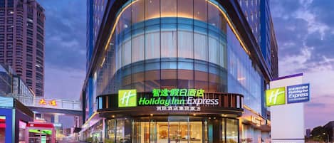 Um hotel moderno com fachada curva, grandes janelas de vidro e a sinalização da Holiday Inn Express.