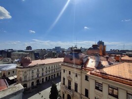 Um edifício histórico com arquitetura clássica, apresentando janelas em arco e um pátio central.