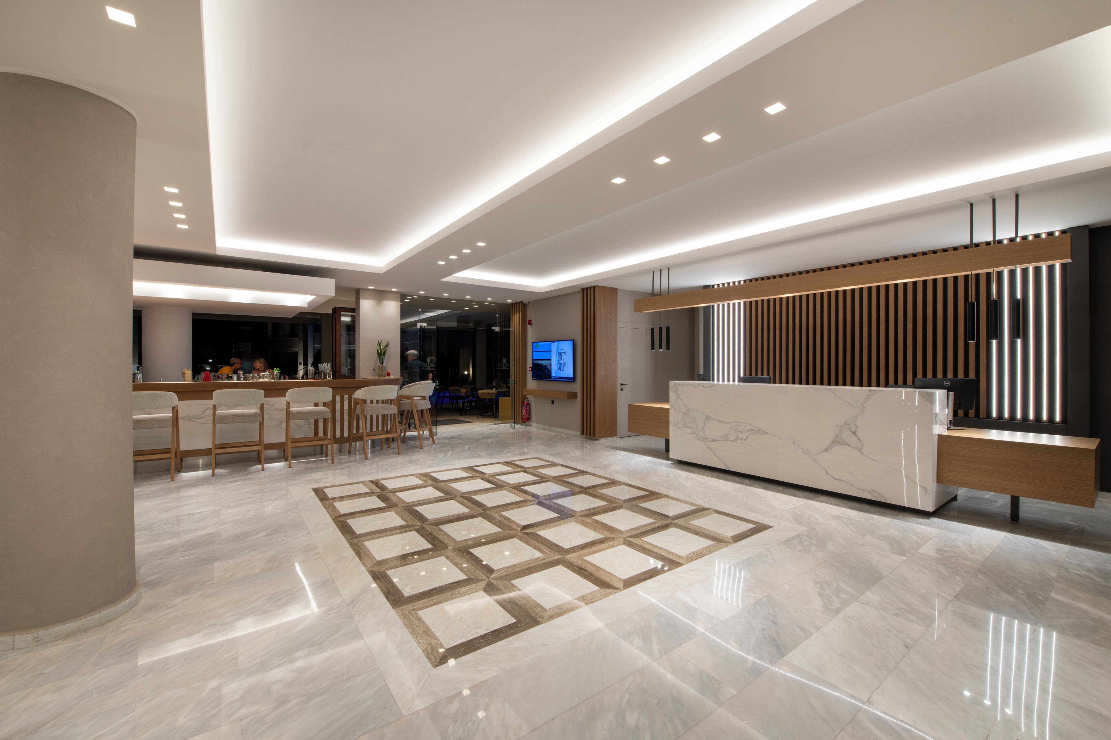 Um lobby moderno com balcão de recepção, área de estar e bar.