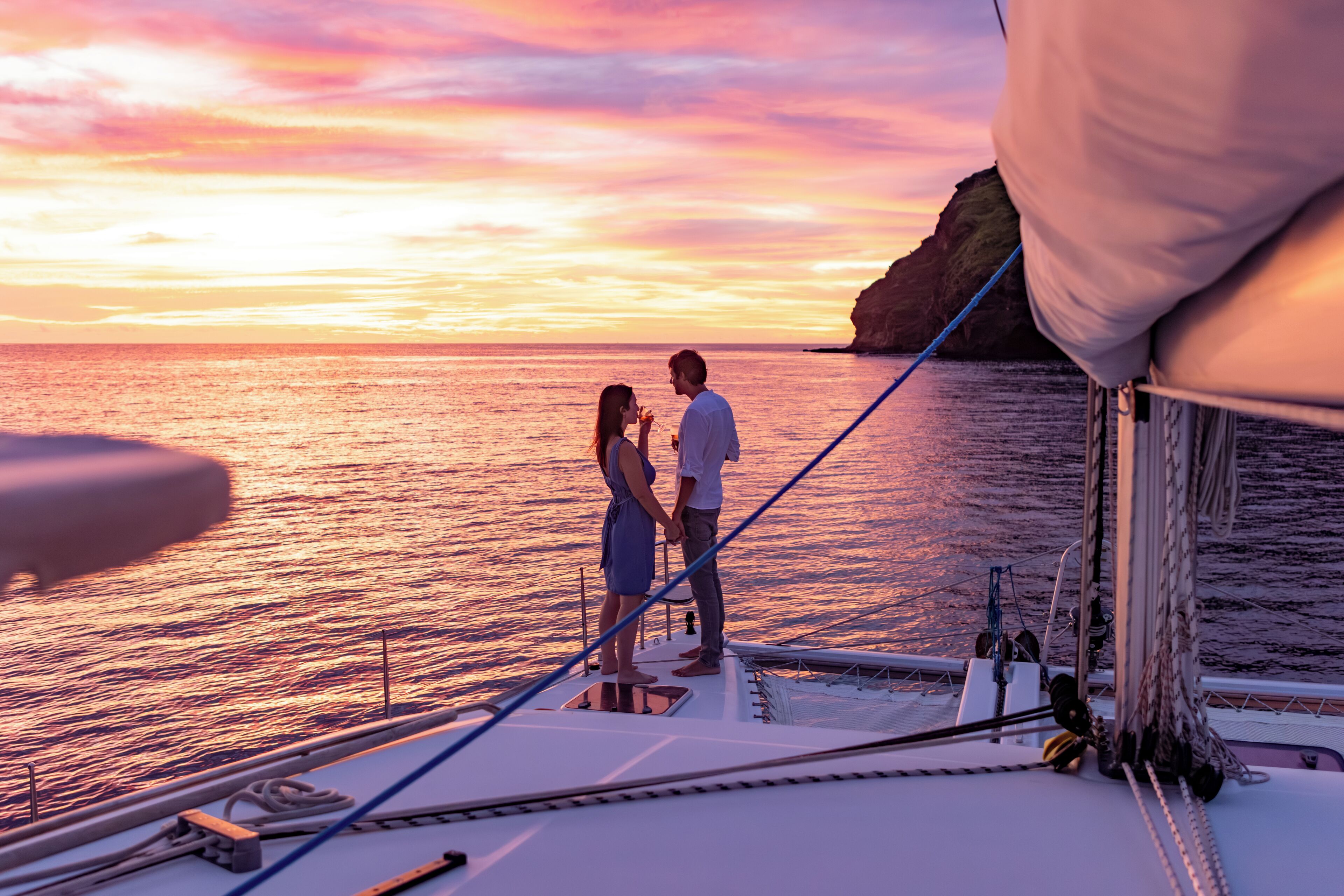 Um casal em um barco com vista para o pôr do sol.