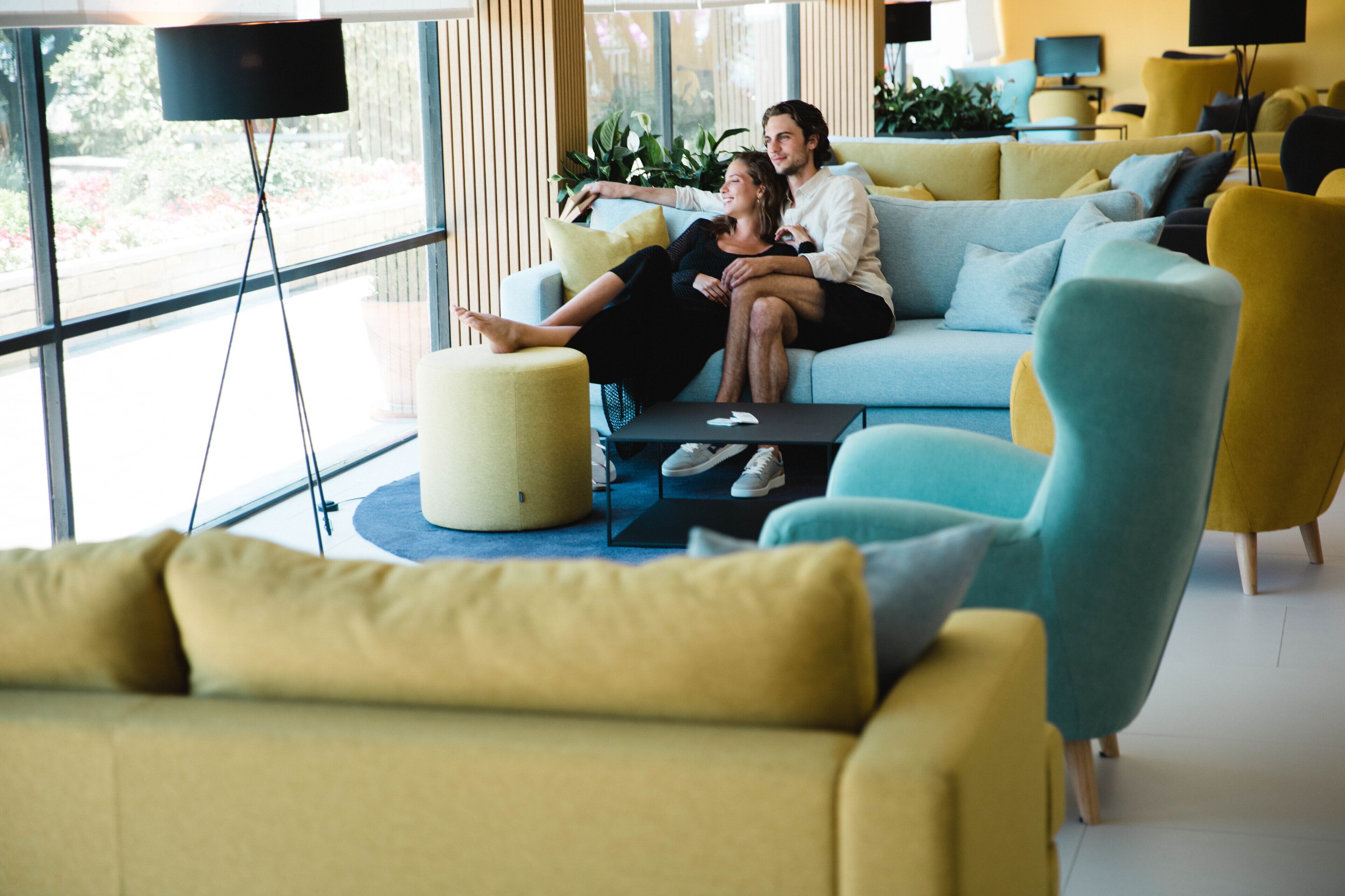 Uma sala de estar moderna com um sofá, poltronas e uma mesa de centro.