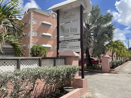 Placa do Restaurante Palm View do Sunbay Hotel, com número de contato e serviços listados.