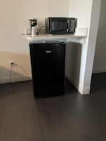 Cozinha compacta com micro-ondas e lava-louças preta.