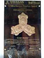 Placa comemorativa de medalha de ouro para o Prêmio de Turismo Tri Hita Karana, concedido aos Cottages Puri Lumbung por Jasmine Hotels.