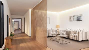 Uma sala de estar moderna com sofás listrados, uma mesa de centro e um biombo decorativo.