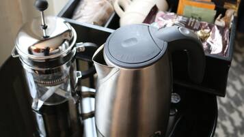 Uma cozinha com cafeteira e chaleira em uma bancada.