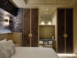 Quarto moderno com uma cama grande, uma escrivaninha e uma cadeira.
