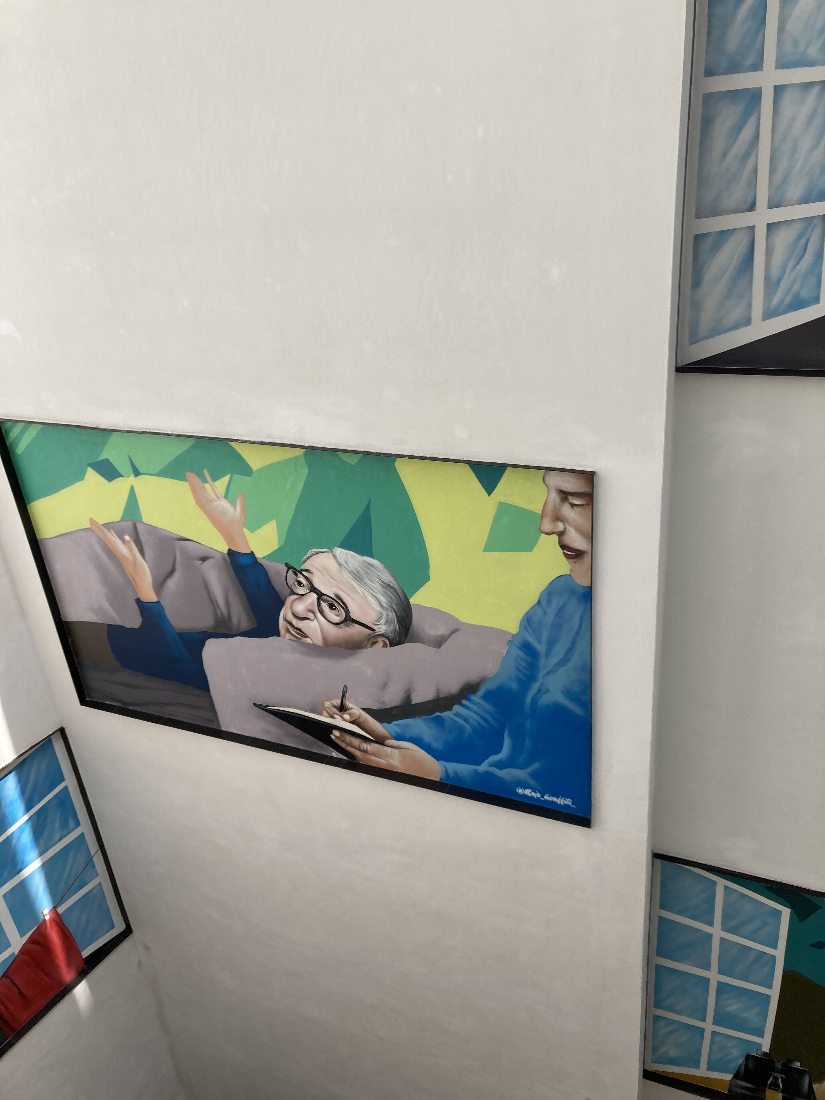 Obra de arte na parede mostrando duas pessoas em um ambiente descontraído.