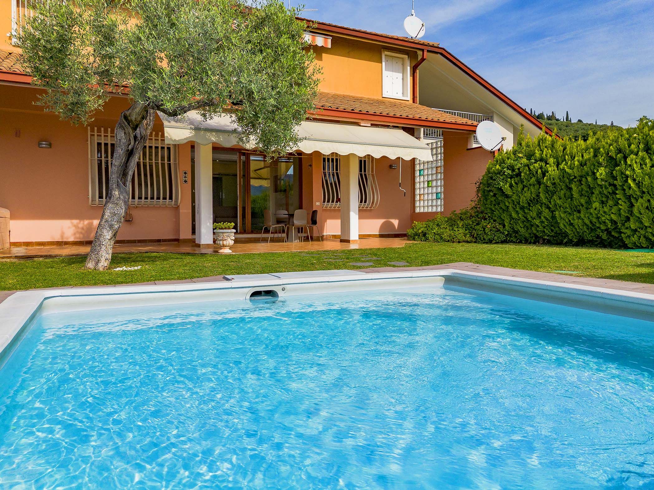 Piscina com uma casa ao fundo.