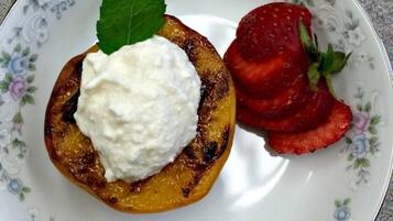 Uma fatia de pêssego grelhado com chantilly e morango.