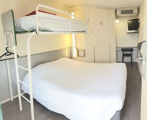 Quarto com beliche, escrivaninha e televisão.