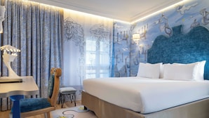 Quarto com uma cama grande, uma escrivaninha com cadeira e um mural na parede.