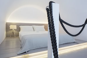 Quarto moderno com cama, mesa de cabeceira e decoração de corda.