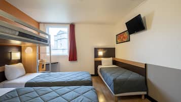Quarto de hotel com duas camas, uma escrivaninha, uma cadeira, uma televisão e uma janela com cortina vermelha.